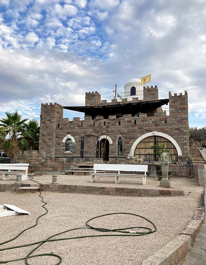 The castle's multi-colored stonework creates a striking contrast against Arizona's blue skies &ndash; medieval fantasy meets desert reality.