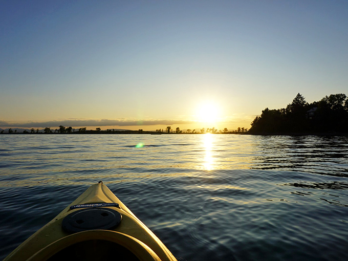 Dawn breaks over calm waters, turning an ordinary kayak adventure into a journey across nature's most perfect mirror.