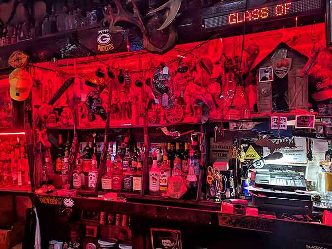The bar glows with an otherworldly red light, illuminating bottles and the eclectic collection of memorabilia that makes every glance a new discovery.