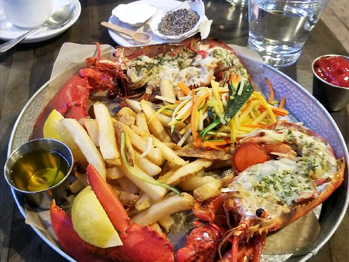 This isn't just a lobster dinner; it's a crustacean celebration! Golden fries, vibrant slaw, and that magnificent red creature demanding your full attention.
