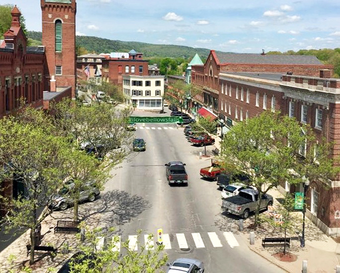 A panoramic view of Bellows Falls reveals its picturesque setting along the Connecticut River, surrounded by Vermont's rolling hills.