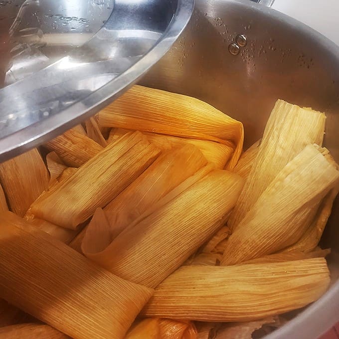 Steaming corn husks cradle these handmade treasures – each one a perfect package of tender masa surrounding savory, slow-cooked fillings that define comfort food.