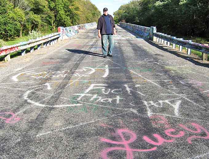 A solitary explorer stands amid the chaos of color, perhaps wondering if the bridge's legendary spirits are watching.