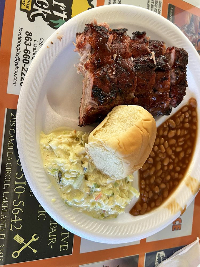 Baby backs nestled beside creamy coleslaw and beans that have clearly been simmering alongside the smoky meats. A holy trinity of barbecue bliss.