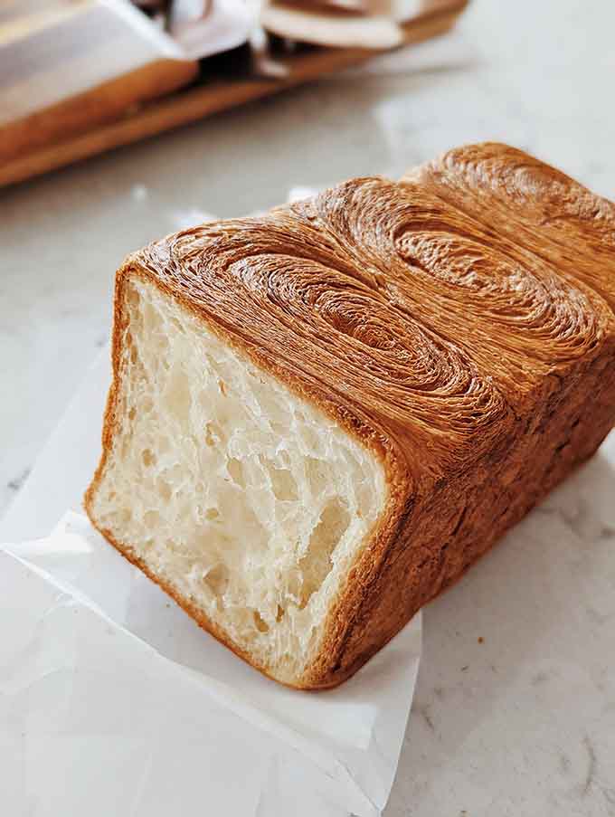 That cross-section reveals the layers of flaky perfection that make this loaf worth writing home about, or at least texting everyone you know.