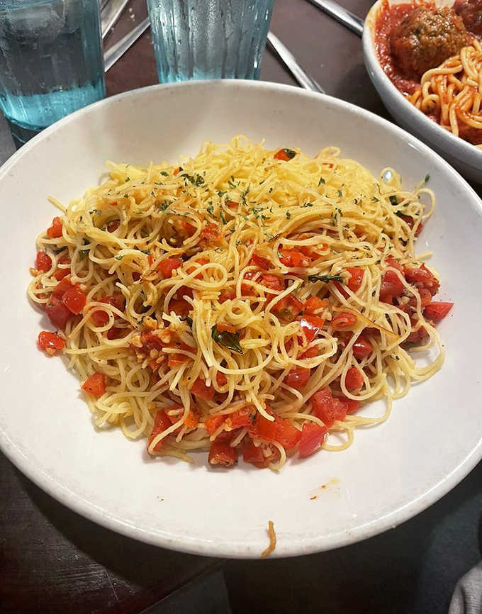 Cappellini Pomodoro that whispers of summer gardens &ndash; angel hair pasta dancing with fresh tomatoes and herbs in perfect harmony.