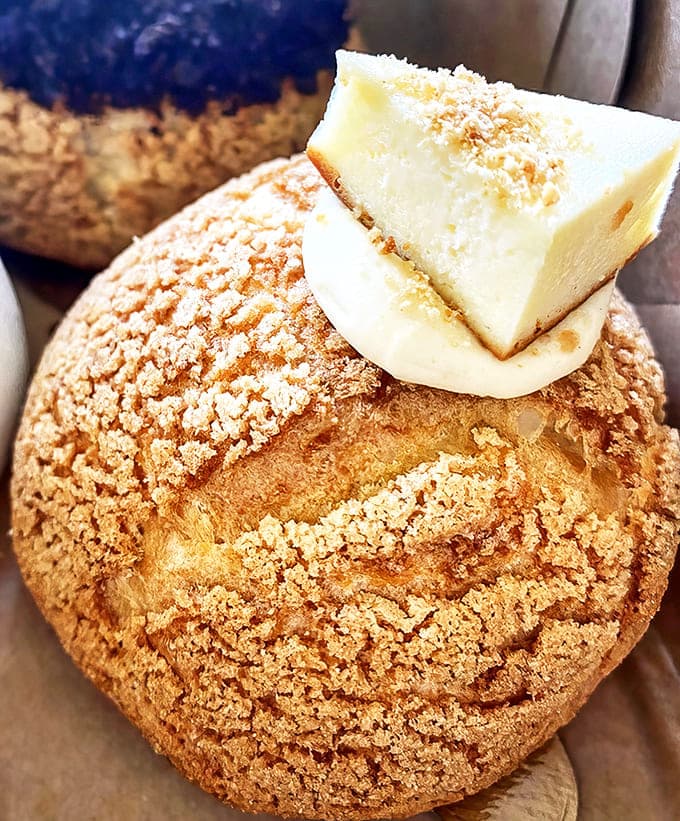 The cheesecake cream puff combines two beloved desserts into one perfect bite, topped with a slice of creamy heaven.