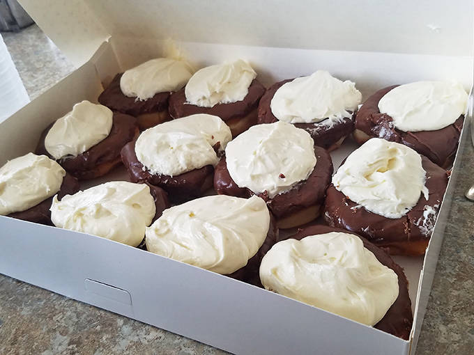Chocolate-covered custard donuts present life's sweetest dilemma: nibble around the edges first or dive straight into that creamy center?