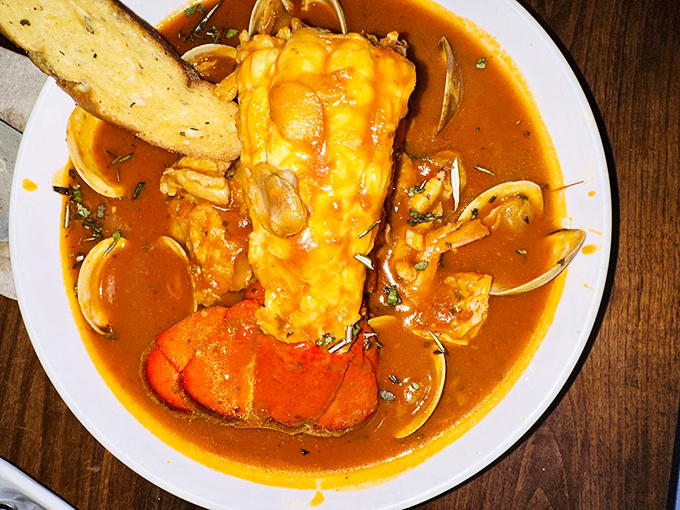 The Cioppino arrives like a treasure chest from the sea, brimming with lobster, clams, and fish in a rich tomato broth.