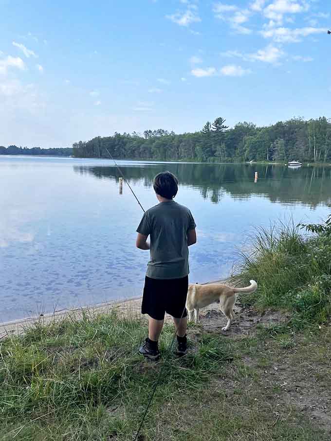 A peaceful moment between angler and lake, with a faithful canine companion completing this quintessential Michigan outdoor scene.