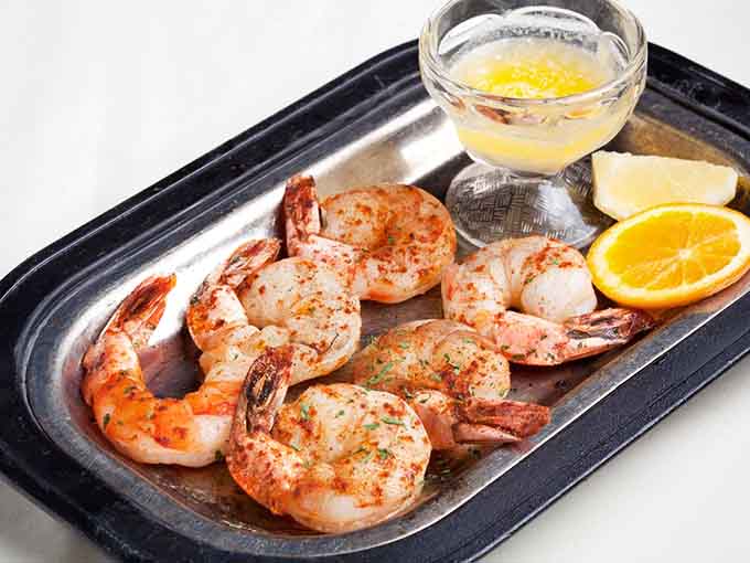 Plump, perfectly broiled shrimp arrive sizzling hot, ready to deliver sweet, succulent seafood satisfaction with every bite.