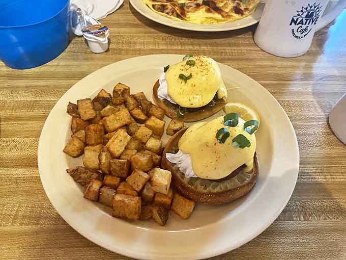 Another angle of the legendary Crab Cakes Benedict reveals the generous portion of crispy home fries, creating the breakfast plate of champions that's worth every calorie.