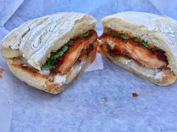 Golden-fried perfection meets garden-fresh greens in this architectural marvel of a sandwich that demands to be devoured immediately.