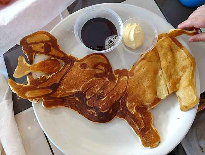 A dinosaur pancake with syrup and butter proves breakfast doesn't have to be boring to be delicious.