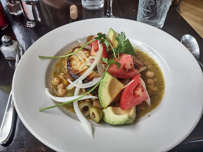 A perfectly seared fish fillet nestled in a bed of chickpeas, topped with fresh avocado and tomato &ndash; proof that simplicity, when executed flawlessly, creates magic.