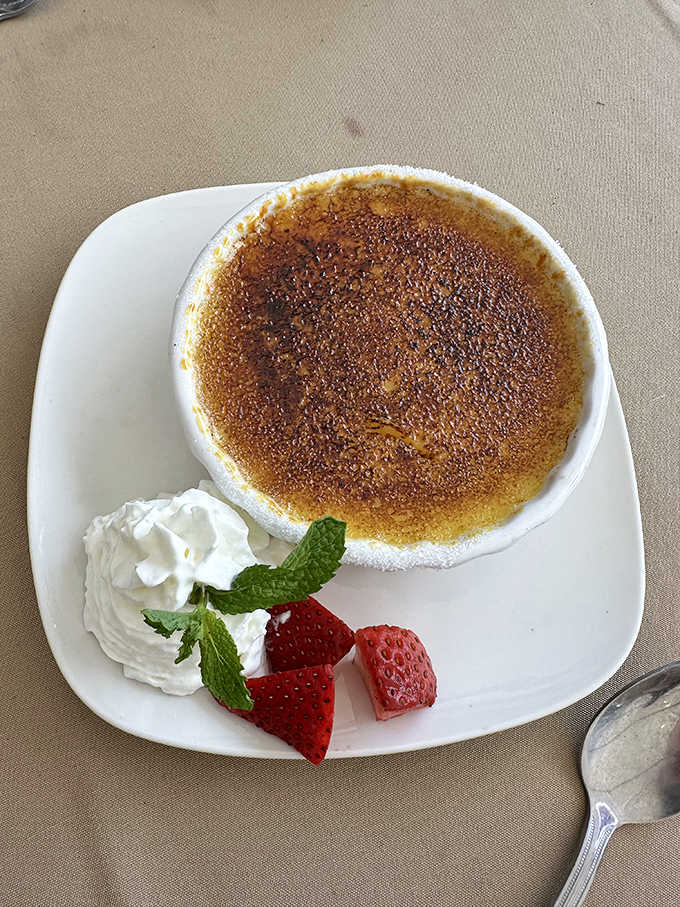 The cr&egrave;me br&ucirc;l&eacute;e's caramelized top shatters like thin ice, revealing a silky pond of vanilla-infused bliss beneath.