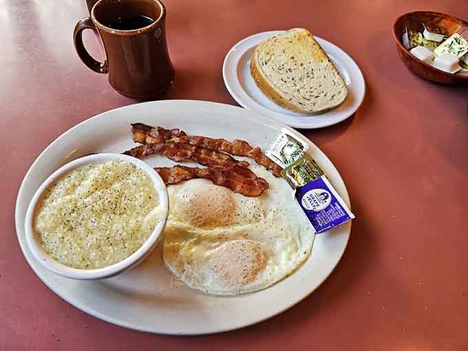 Two eggs, bacon, grits, and toast prove that sometimes the simplest combinations create the most satisfying meals.
