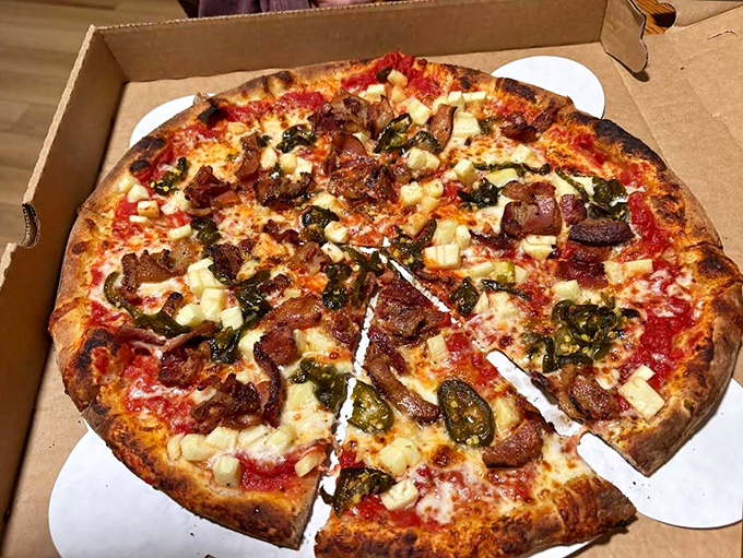 The Hawaiian pizza gets a gourmet makeover with fresh pineapple, savory bacon, and that signature wood-fired char that elevates every ingredient.