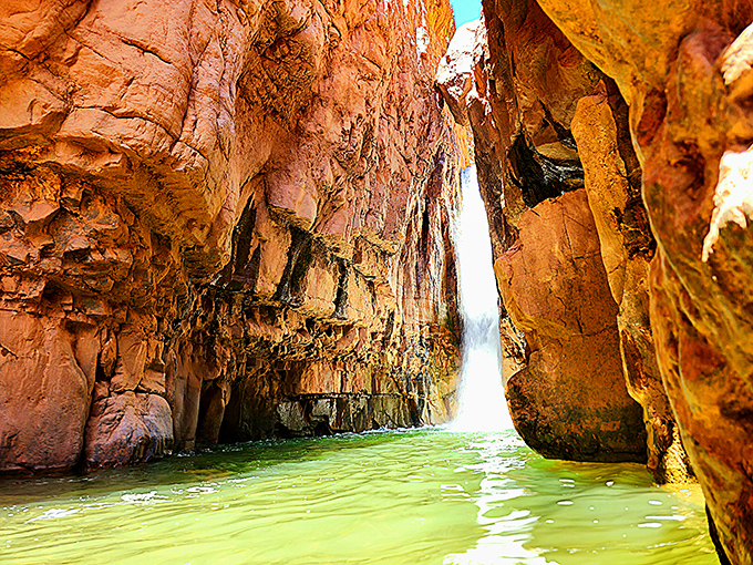 A secret swimming hole awaits beneath the falls, its emerald waters offering sweet relief after the trek through Arizona's rugged wilderness.