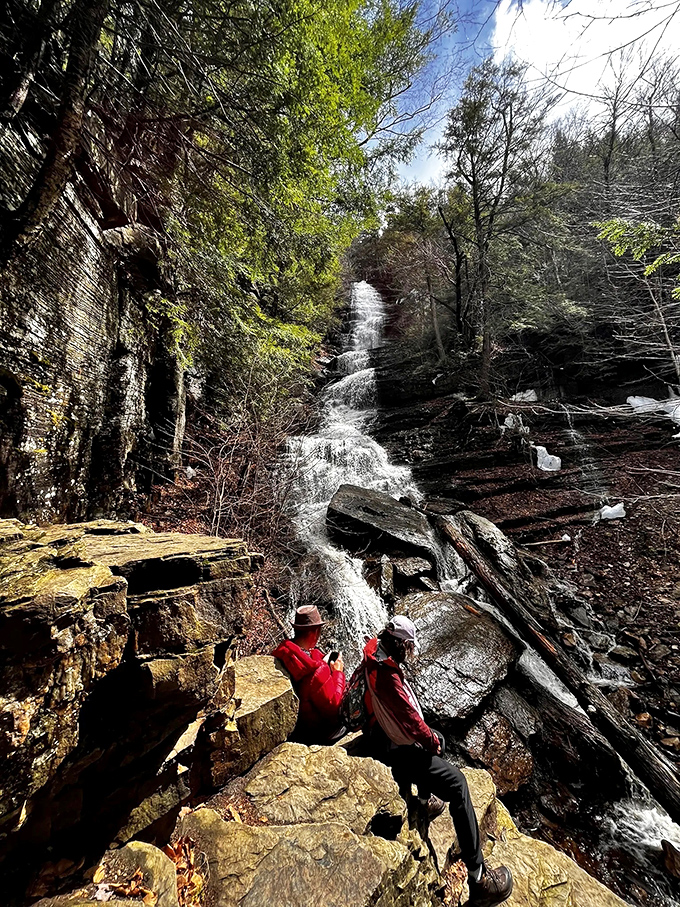 Intrepid hikers pause to capture the moment at the falls' base. Some views simply demand to be remembered.