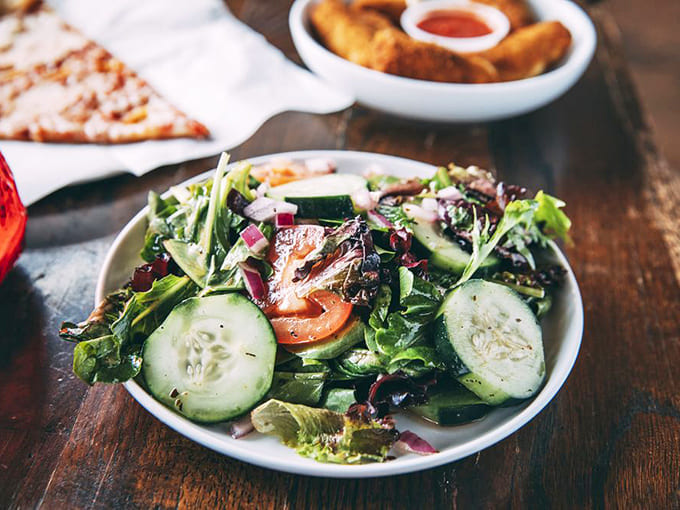 Fresh ingredients shine in Dante's house salad &ndash; crisp greens, ripe tomatoes, and cucumbers provide the perfect pizza accompaniment.