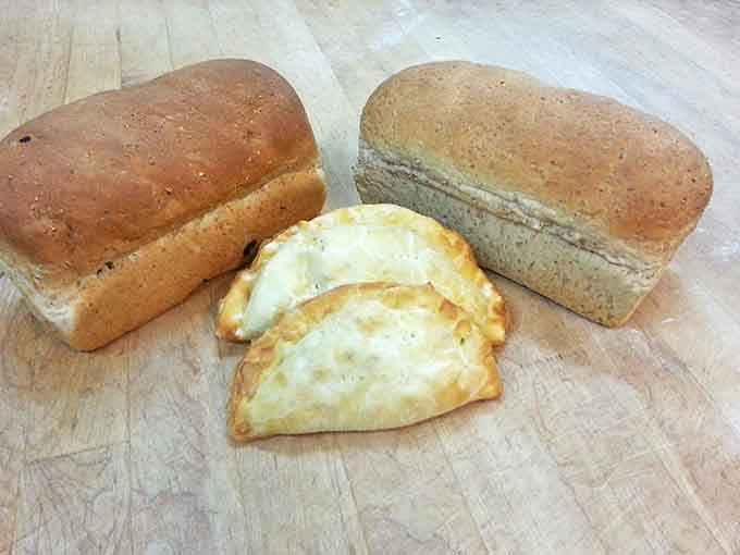 The holy trinity of Upper Midwest baking: hearty pasties flanked by fresh-baked bread loaves that smell like childhood memories.