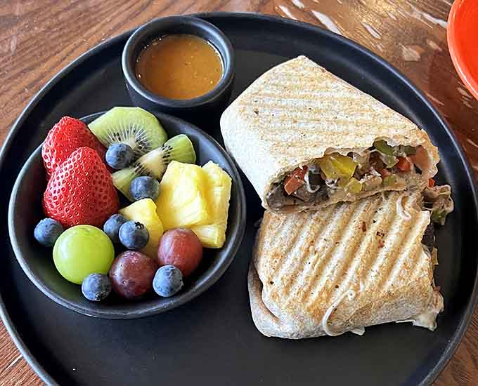 This breakfast burrito arrives with a rainbow of fresh fruit that's almost too pretty to eat. Almost.