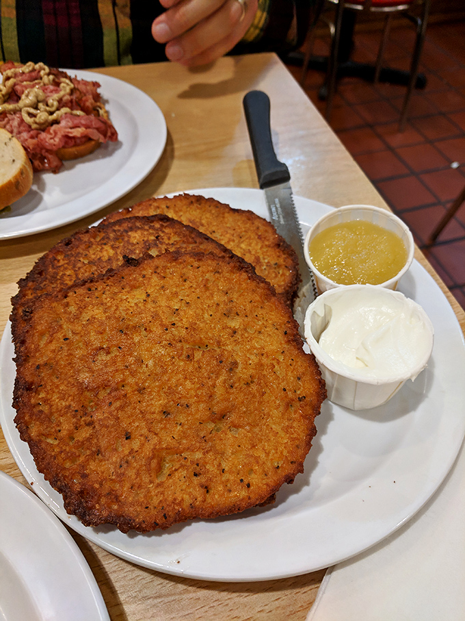 Golden-brown potato latkes with the perfect crisp exterior give way to tender, savory centers – a hand-grated masterpiece served with traditional accompaniments.