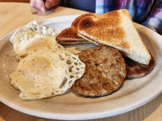 A classic breakfast done right: perfectly cooked eggs, sausage patties with just the right spice, and toast ready for butter's melty embrace.