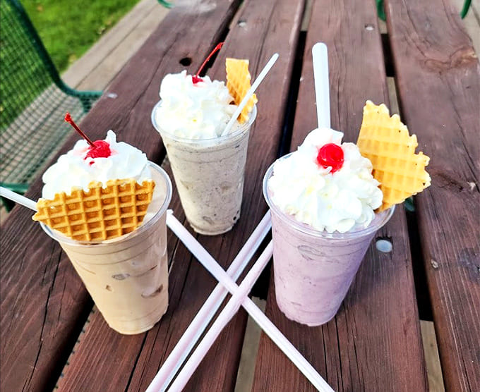 Milkshakes: The holy trinity of malted perfection, each crowned with whipped cream mountains and waffle cookie scepters fit for dessert royalty.