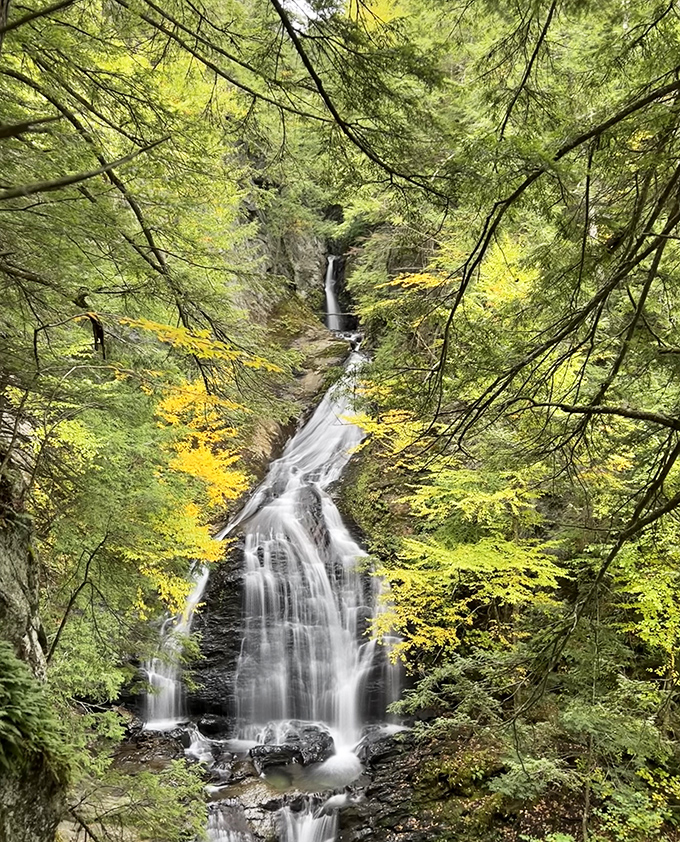Moss Glen Falls cascades through vibrant autumn foliage, one of several spectacular waterfalls accessible via Stowe's network of hiking trails.