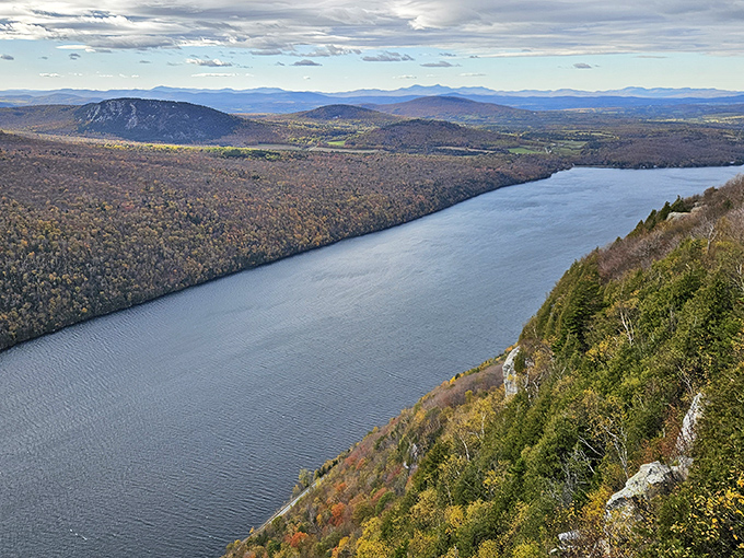 The Northeast Kingdom unfolds below like a rumpled green blanket, with Lake Willoughby cutting a dramatic blue path through the hills.