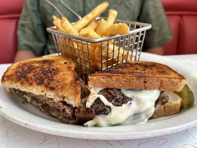 The patty melt arrives with melted cheese oozing everywhere, accompanied by fries that deserve their own fan club.