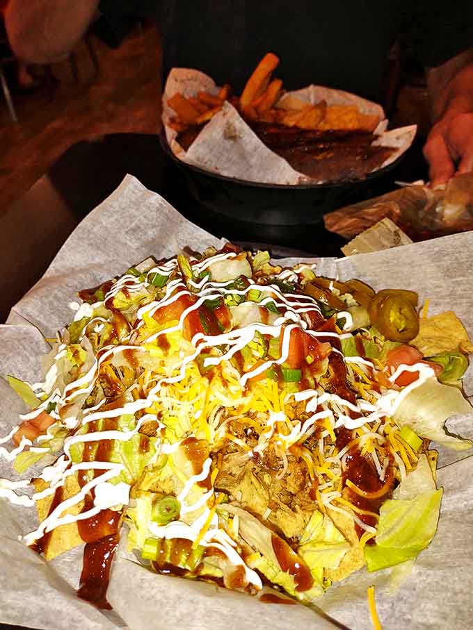 Tortilla chips playing the supporting role of a lifetime, nearly disappearing beneath mountains of pulled pork, cheese, and tangy sauce.