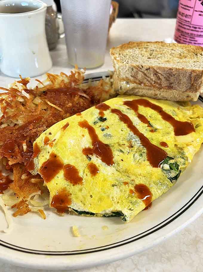 This isn't just an omelet &ndash; it's a masterpiece of morning engineering, with perfectly folded eggs embracing fresh ingredients under a drizzle of house sauce.
