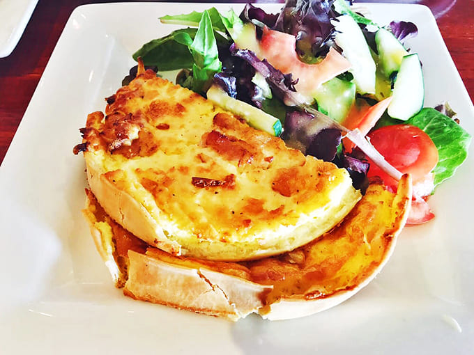 Quiche Lorraine done right &ndash; a golden crown of egg custard studded with bacon and cheese, served with a fresh side salad.