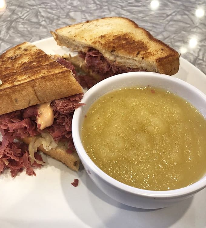That golden applesauce provides the perfect sweet contrast to all that savory corned beef, proving that unlikely pairings sometimes work best.