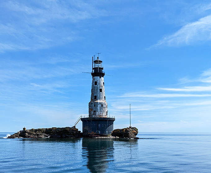The historic Rock of Ages Lighthouse rises dramatically from Lake Superior's waters, a testament to human perseverance against nature's power.