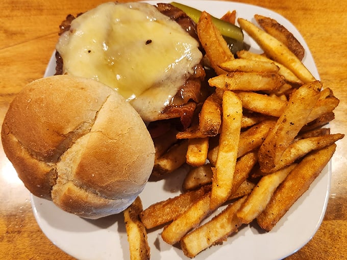 A burger that means business: melted cheese cascading over a perfectly cooked patty, with fries that achieve the golden-crisp ideal.