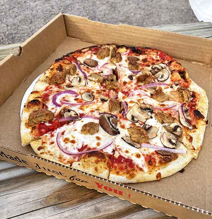 A symphony of flavors: sausage and mushroom dance together atop a perfectly blistered crust from Sydney's legendary wood-fired oven.