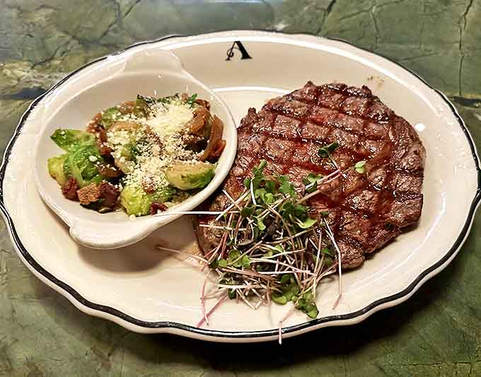 A perfectly grilled ribeye steak shares the plate with a side dish that's clearly not playing a supporting role.