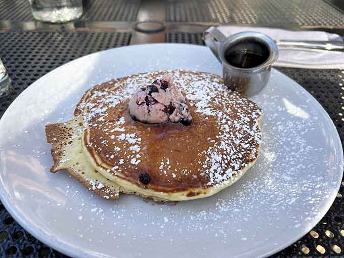 Stack 'em high and watch the maple syrup cascade down like a delicious waterfall, each fluffy layer hiding pockets of sweet, tangy blueberry goodness.