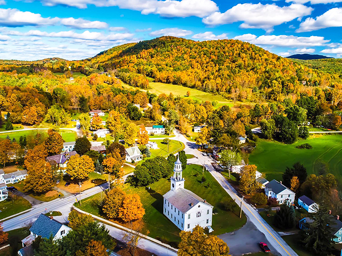 Fall foliage creates a patchwork quilt of crimson and gold around Poultney, showcasing Vermont's most spectacular seasonal transformation.