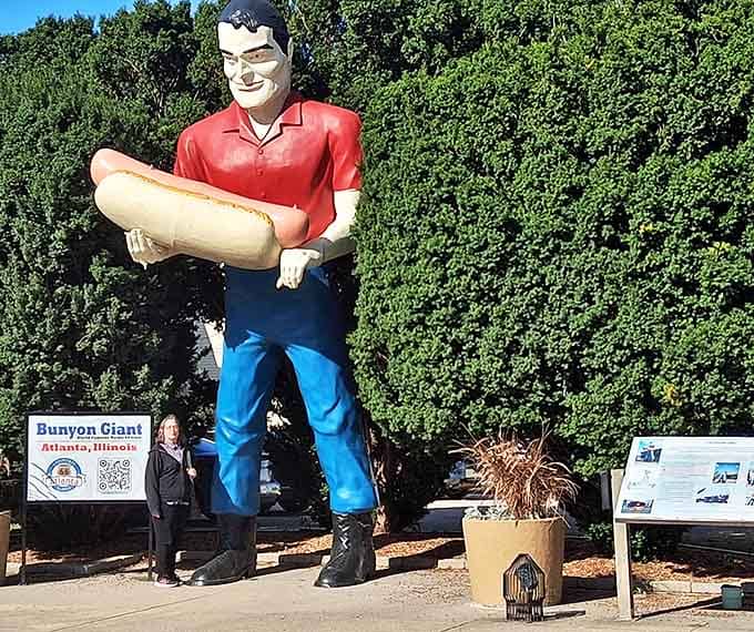 Nothing quite captures scale like a visitor standing beneath the giant, looking like they're about to be served as the side dish.
