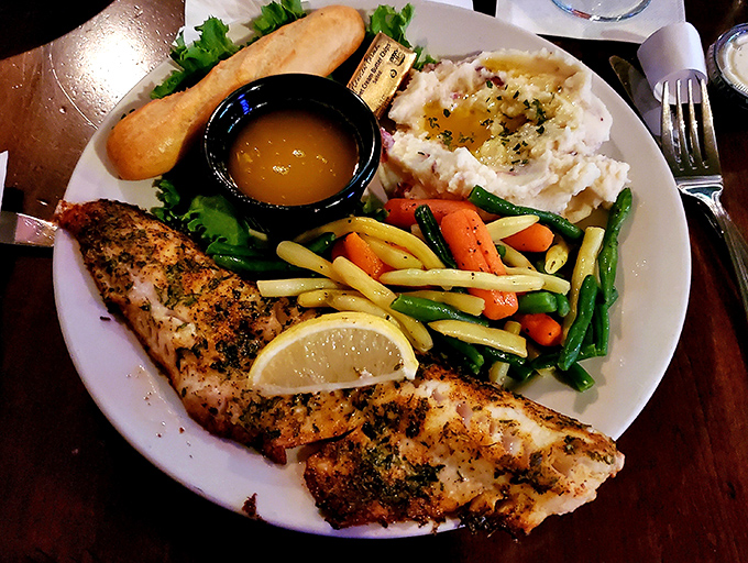 The walleye dinner showcases Minnesota's favorite fish with respect and skill, accompanied by colorful vegetables and cloud-like mashed potatoes.