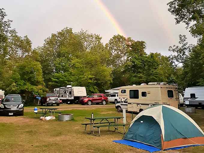 Happy campers find their temporary home under a double rainbow – nature's way of saying you picked the right weekend.