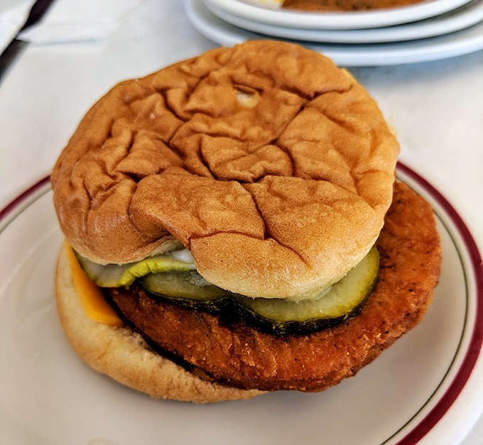 The chicken sandwich arrives unassuming on its throne of wax paper, pickles peeking out like they know something you don't yet.