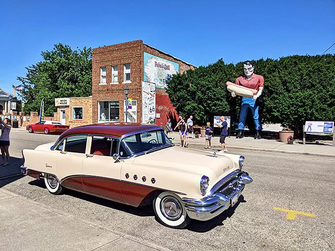 Vintage meets vintage: a classic car poses with the ultimate Route 66 photo op, creating a time-travel postcard moment.