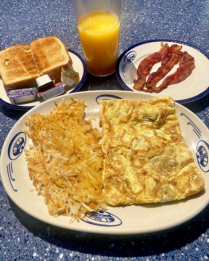 A complete breakfast featuring a fluffy omelet, crispy hash browns, toast, and orange juice – fuel for earthlings and space travelers alike.
