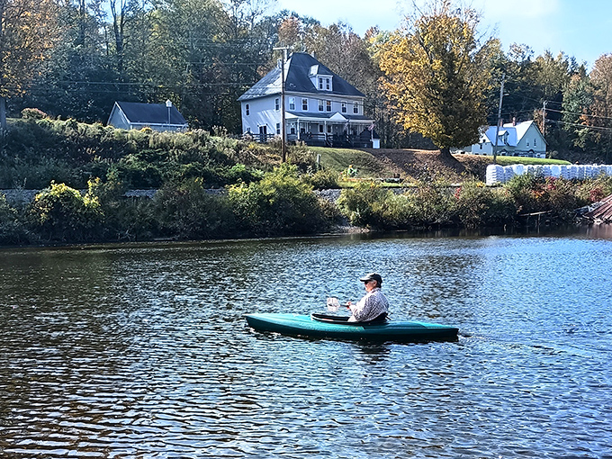 Peaceful paddling: A solitary kayaker enjoys the serene waters of Crystal Lake, surrounded by Vermont's natural beauty.